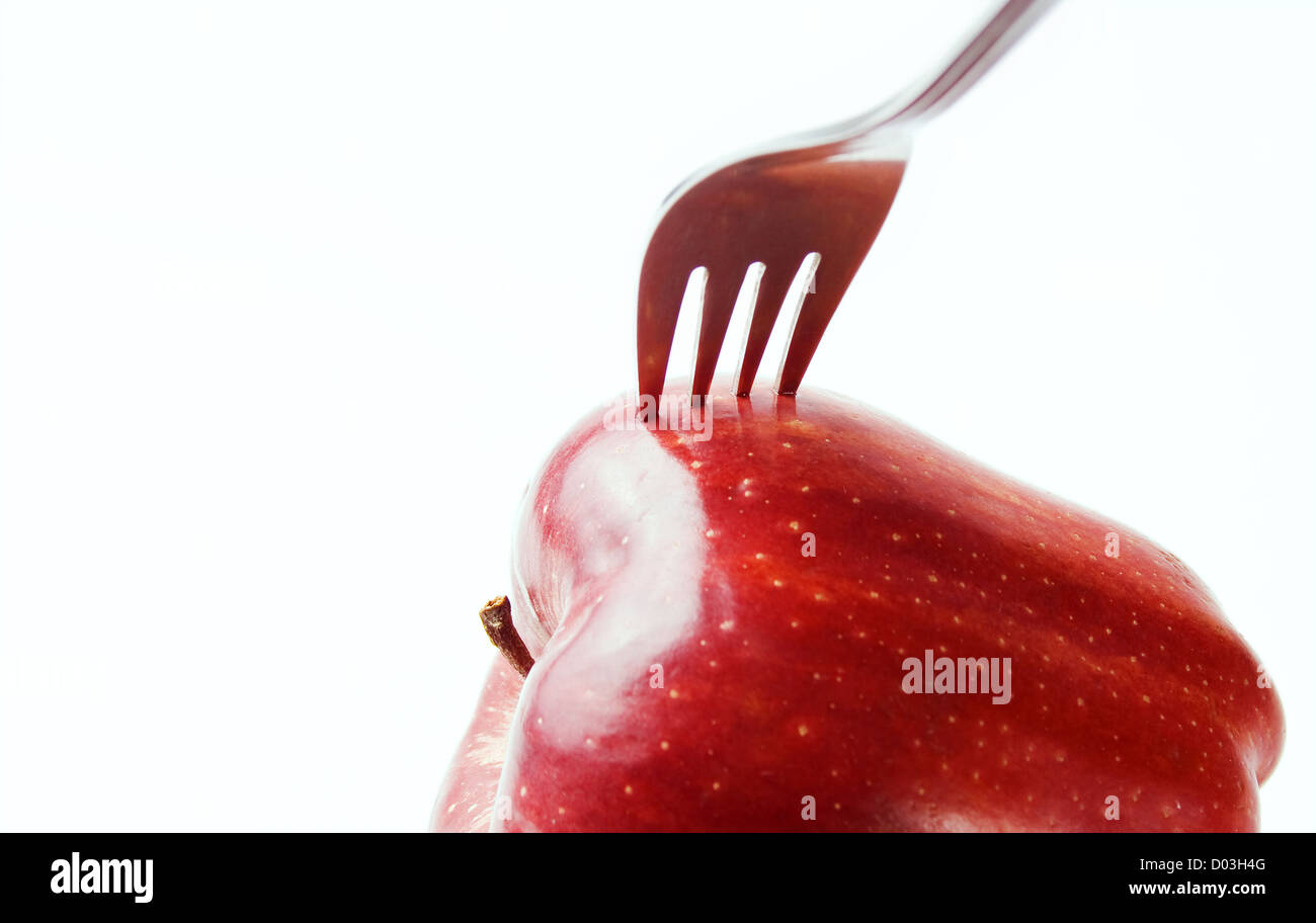 Big red apple with a fork stuck in it isolated on white background ...