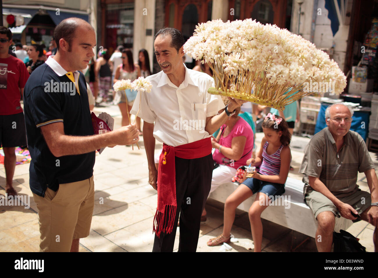 Local man selling flowers in the street at the Malaga Fair, Andalusia ...