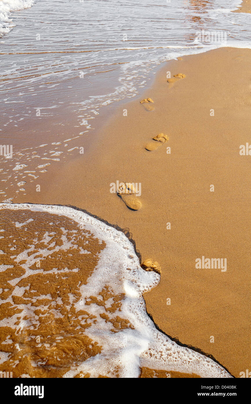 Footsteps on the beach by the sea in summer Stock Photo - Alamy