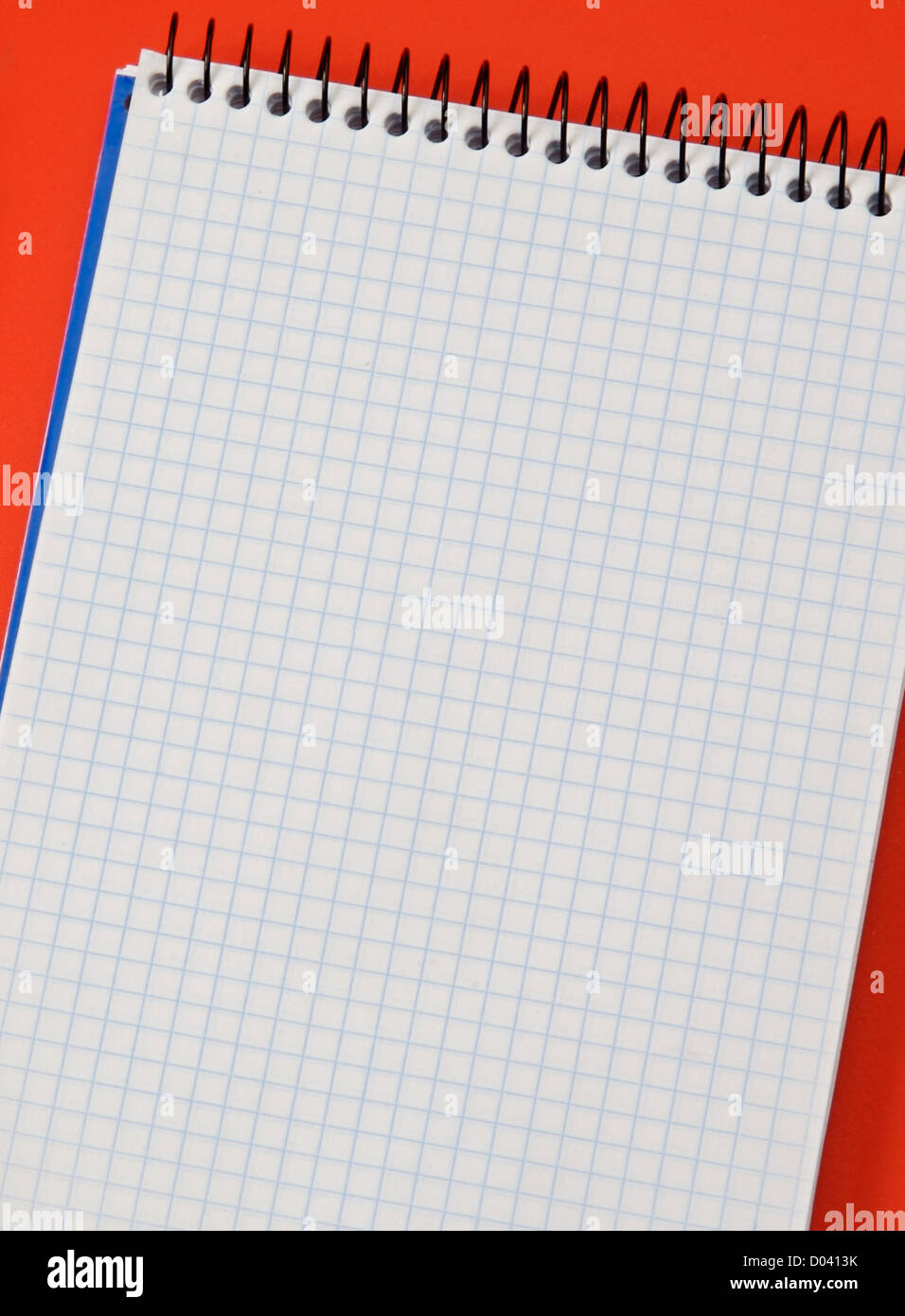 Photo of one notebook in blank with blue squares isolated over red ...