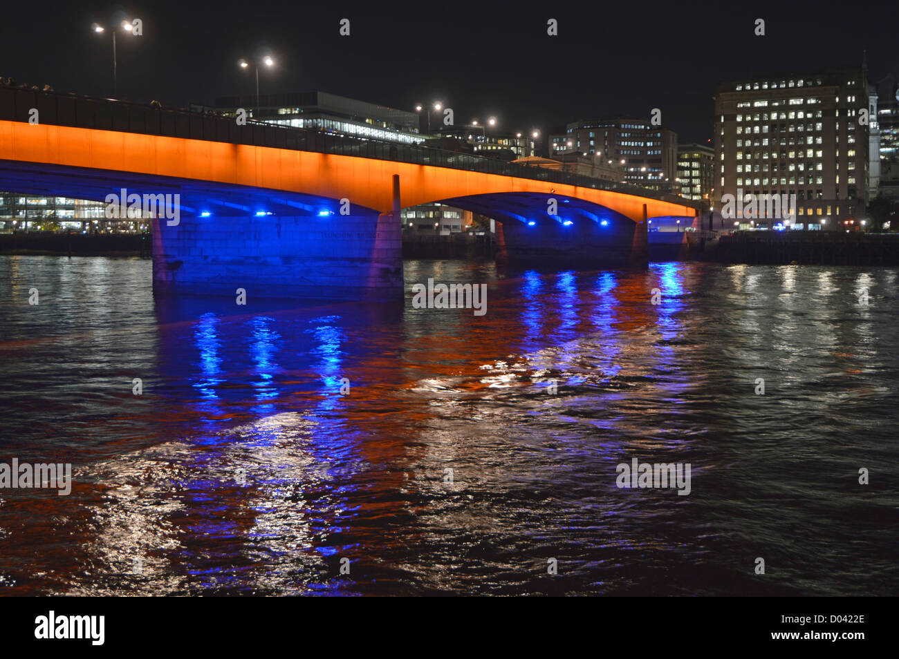Floodlighting on London Bridge with colourful reflections on River ...