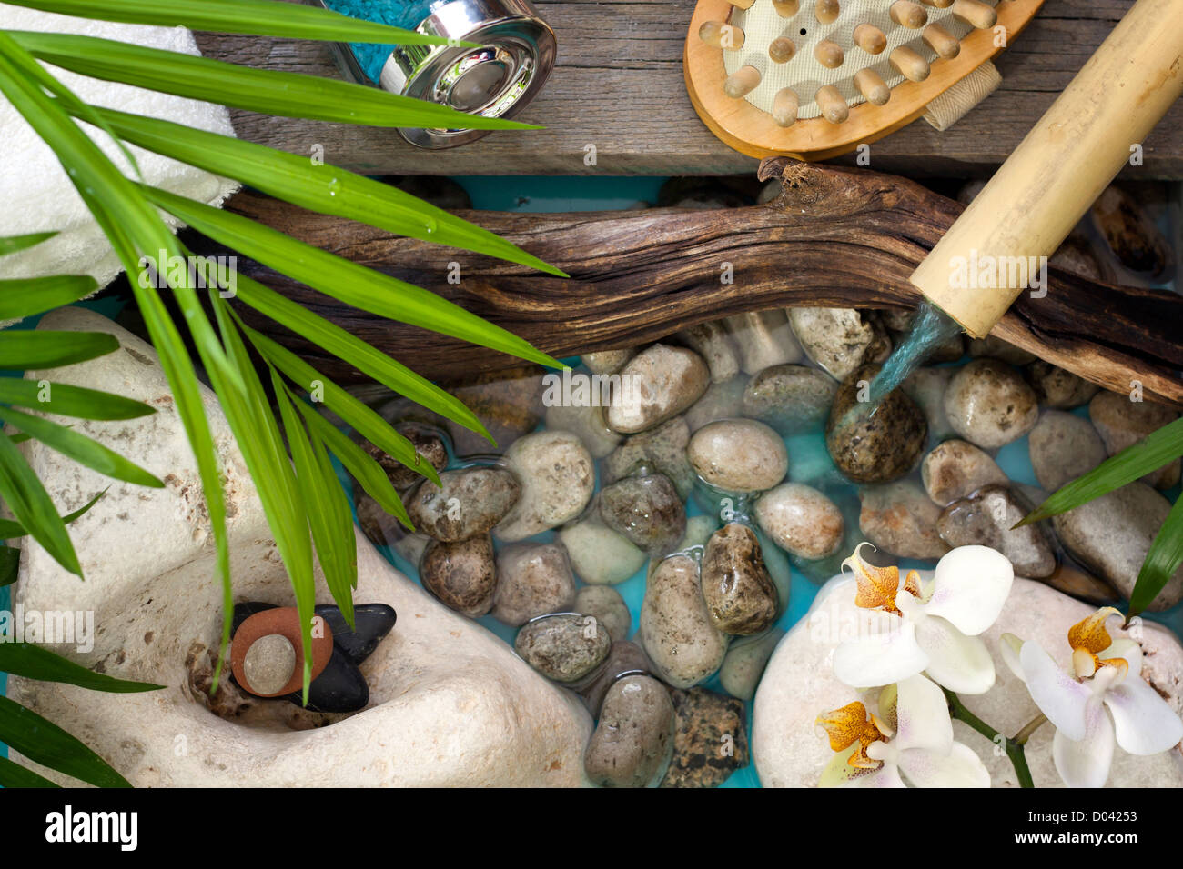 Falling water on stones spa concept background with orchids and bamboo ...