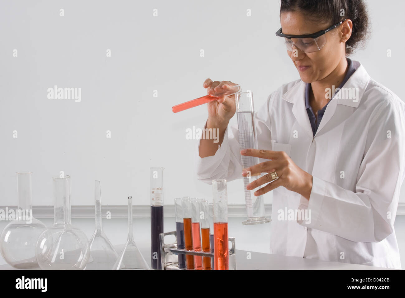Female lab tech mixing liquids Stock Photo - Alamy