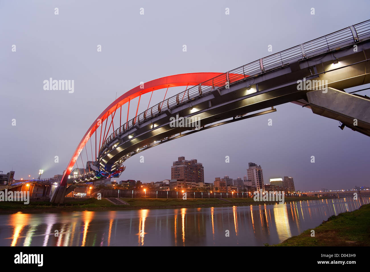Beautiful bridge in red color over river in evening, city night scene ...
