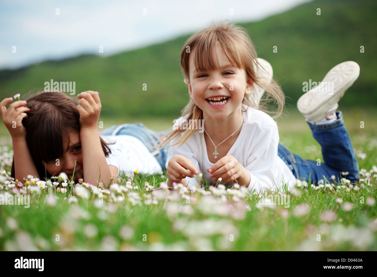 Cute happy children playing in spring filed Stock Photo - Alamy