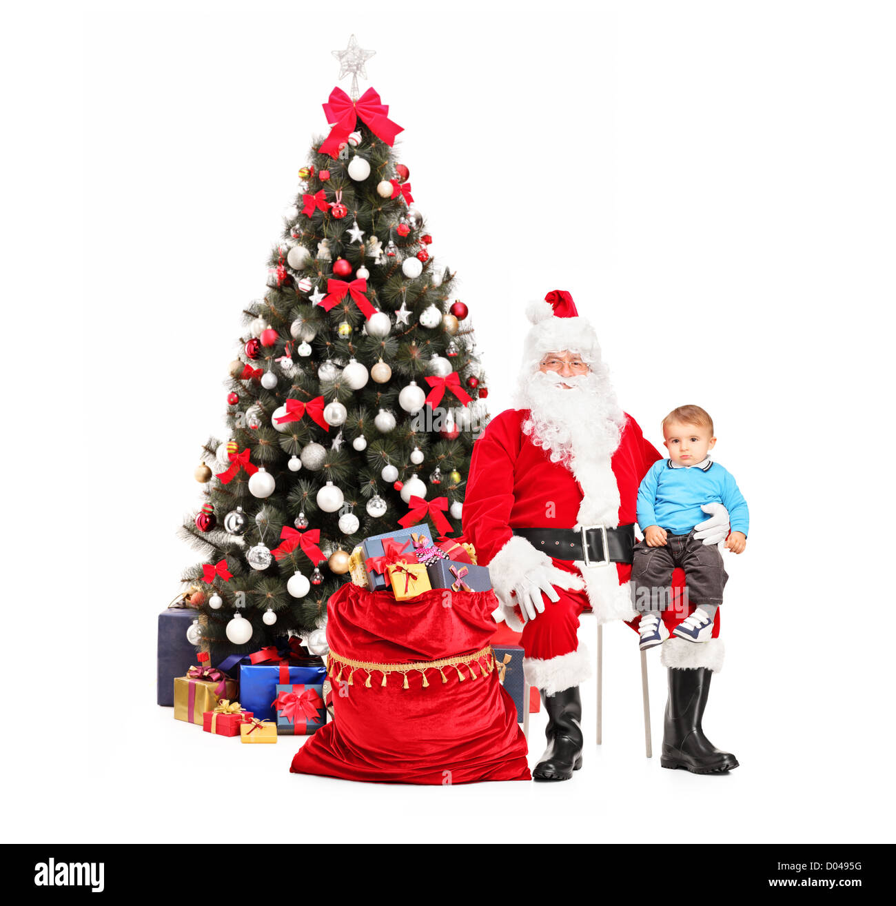 Santa Claus and child on his lap posing, a christmas tree in the ...