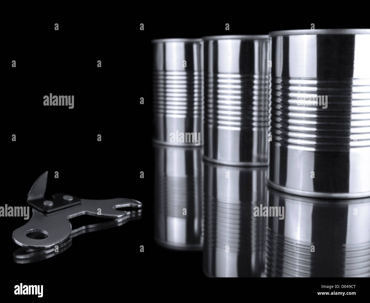 Three tin cans and an opener over a black background Stock Photo - Alamy