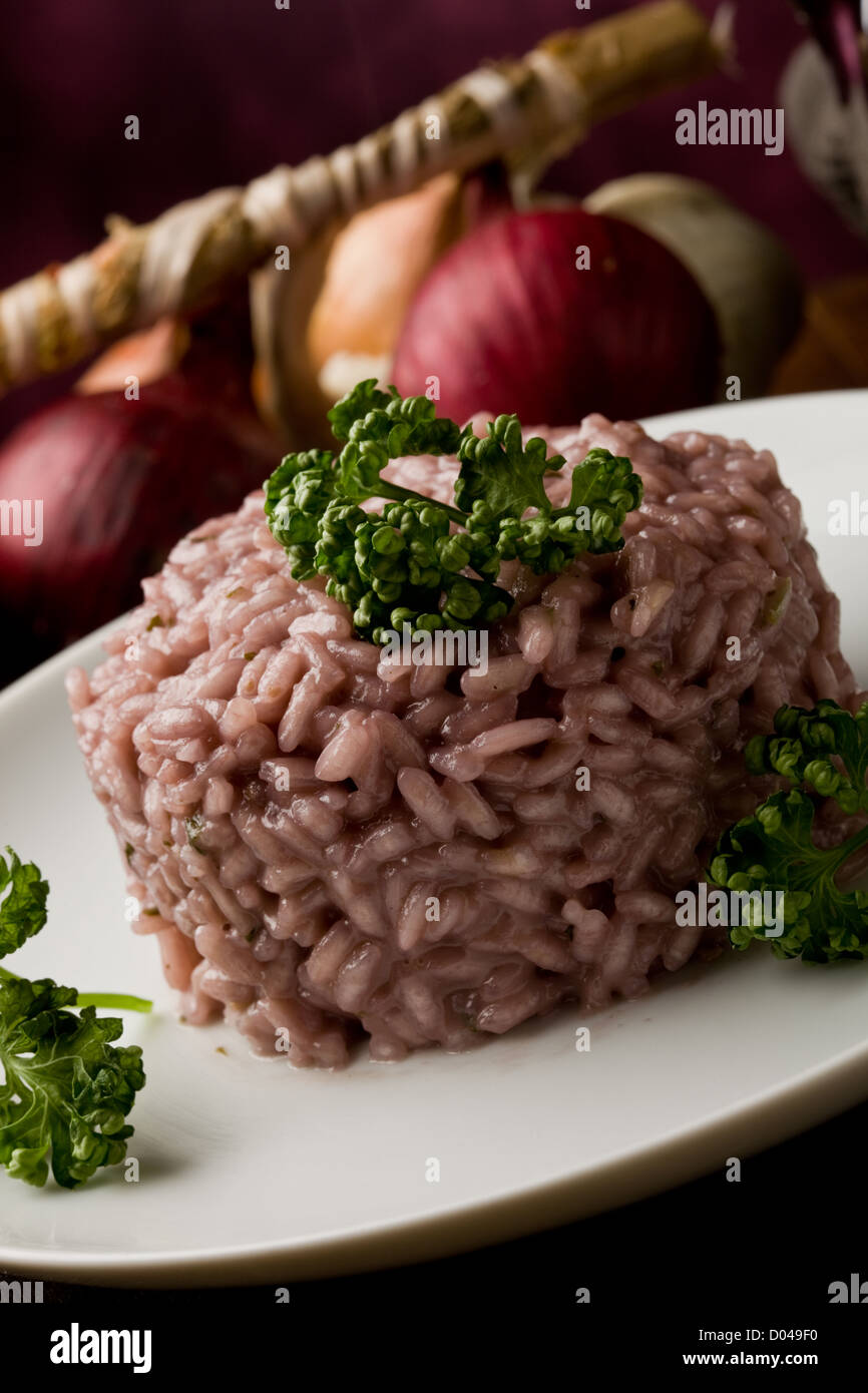 photo of delicious risotto with red wine on wooden table Stock Photo ...
