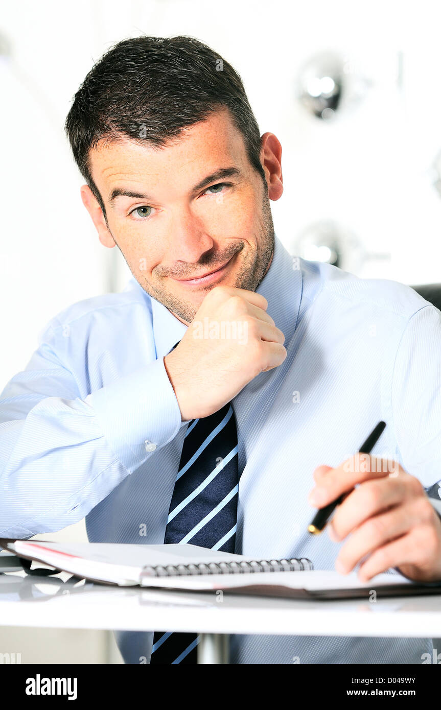 An attractive business man is writing on a paper Stock Photo - Alamy