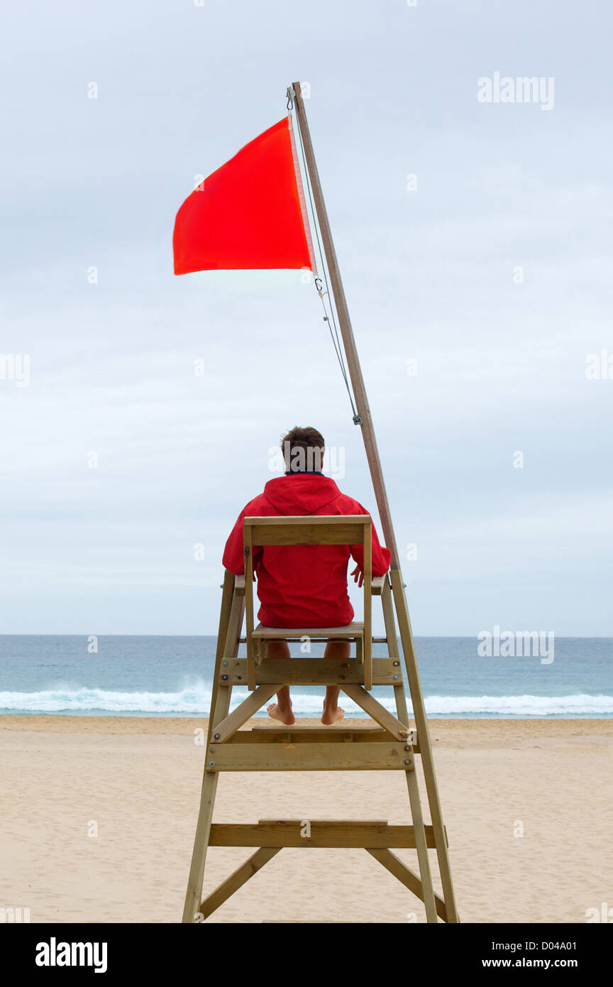 Lifeguard sitting in his chair watching the sea Stock Photo - Alamy