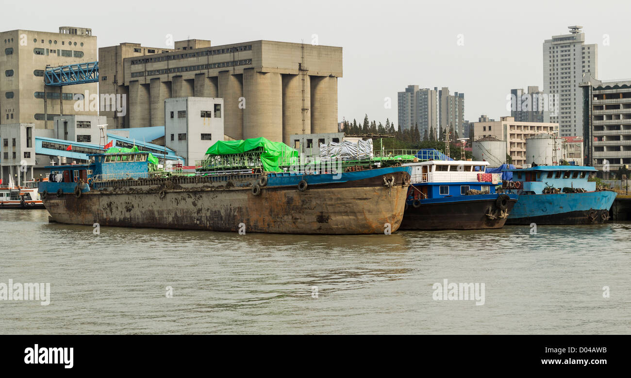 Old Chinese cargo ship docked near storage building on Huangpu River ...