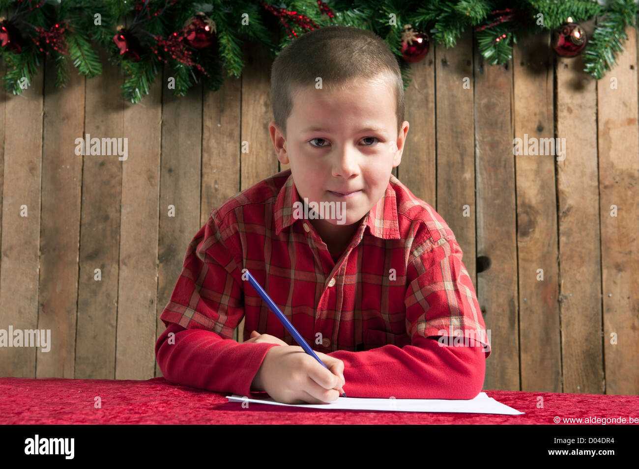 little boy writing a letter for Santa, weathered wooden background ...