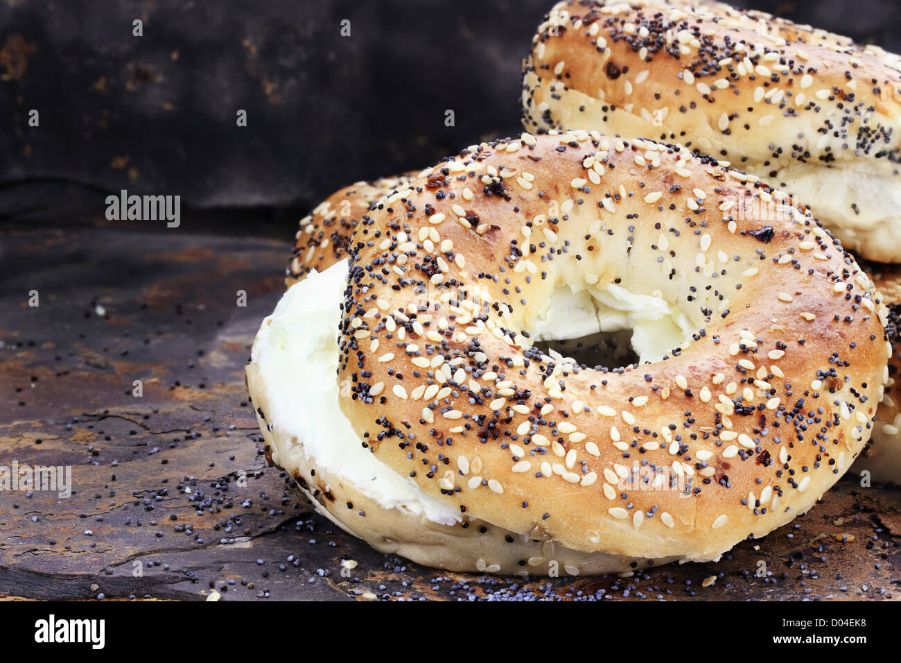 Stack of bagels and cream cheese against a rustic slate background ...
