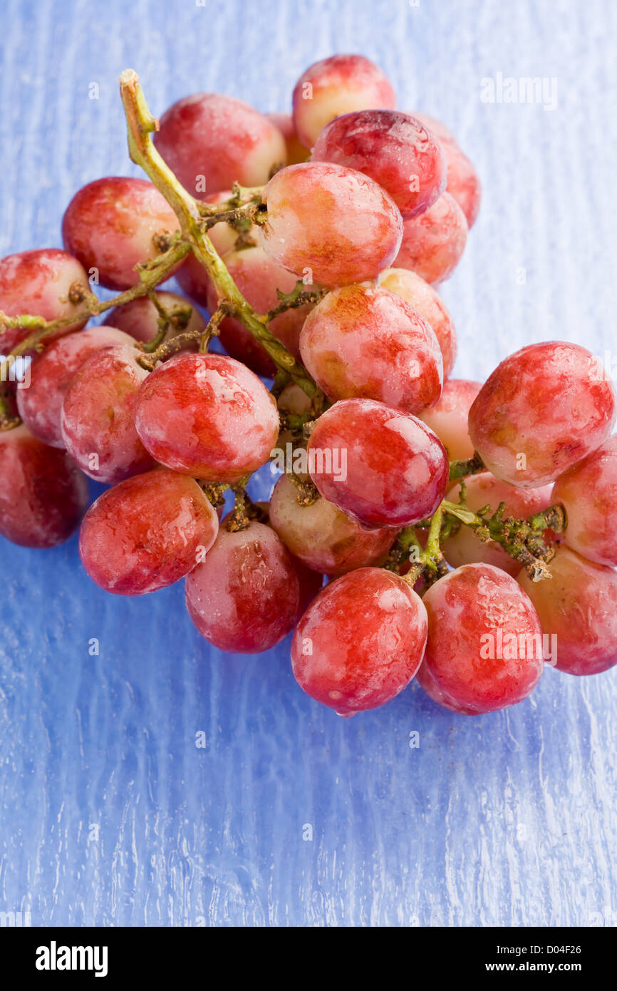 photo of delicious red grape on blue glass table Stock Photo - Alamy