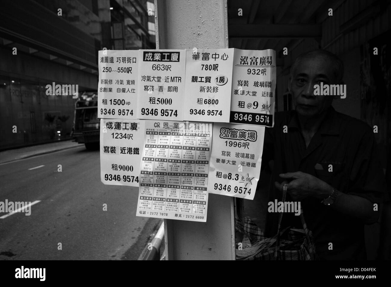man putting up notices, Hong Kong Stock Photo - Alamy
