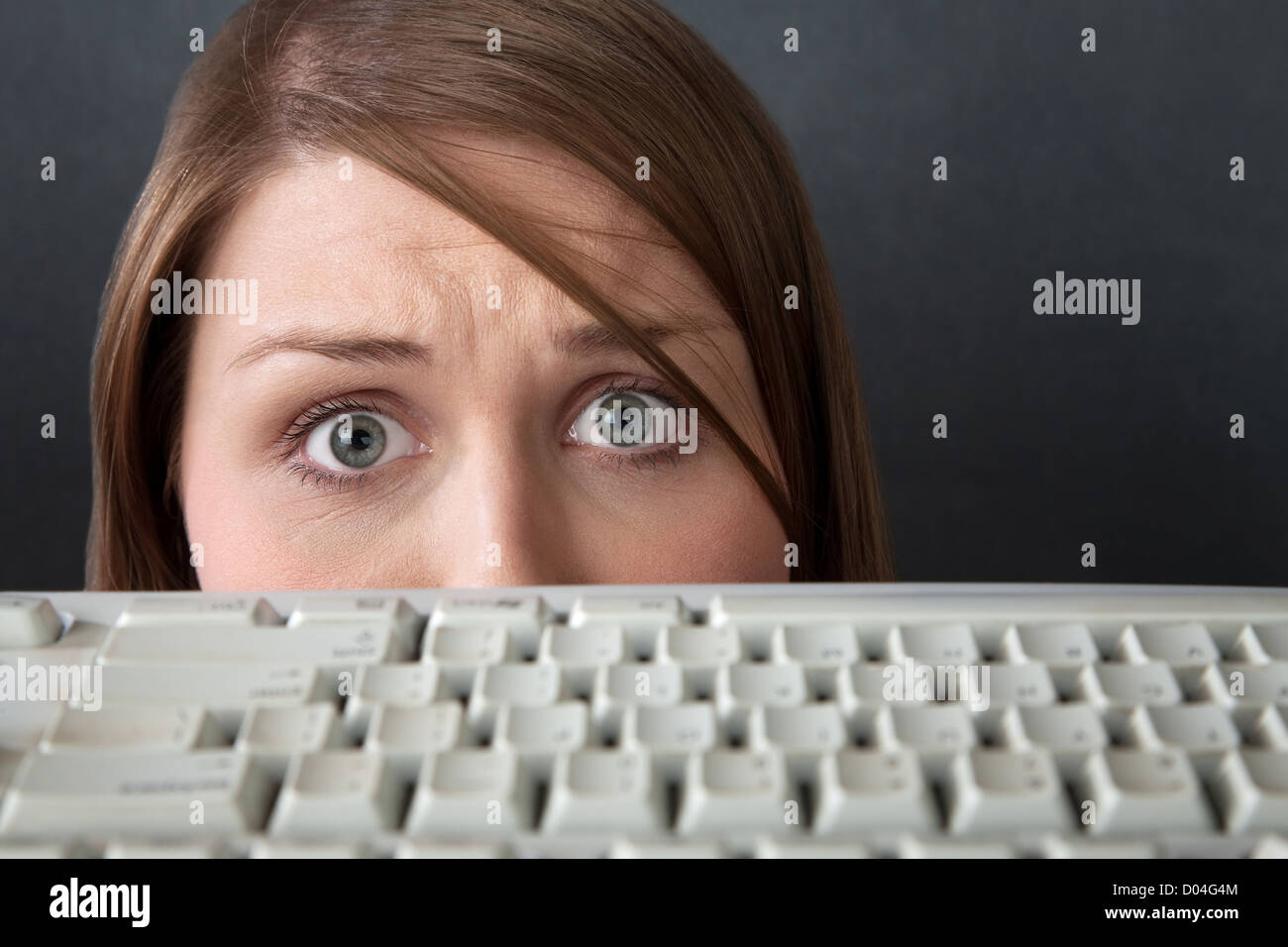 Nervous wide-eye Caucasian woman in front of a computer keyboard Stock ...