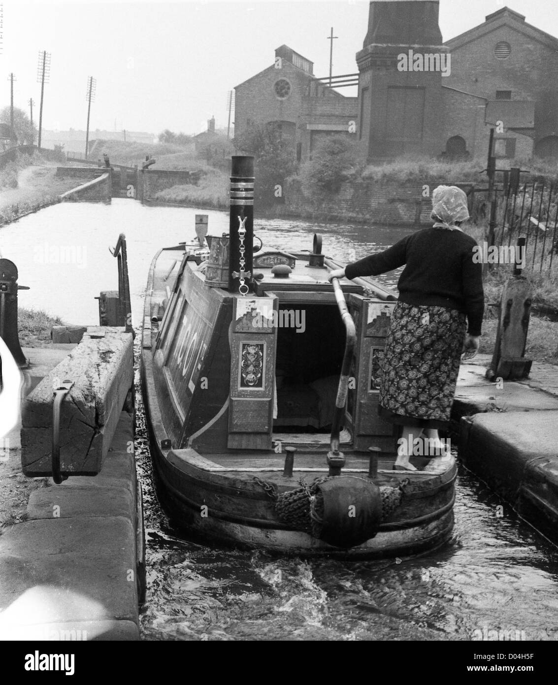 Woman taking a canal narrowboat through a lock in the Black Country ...