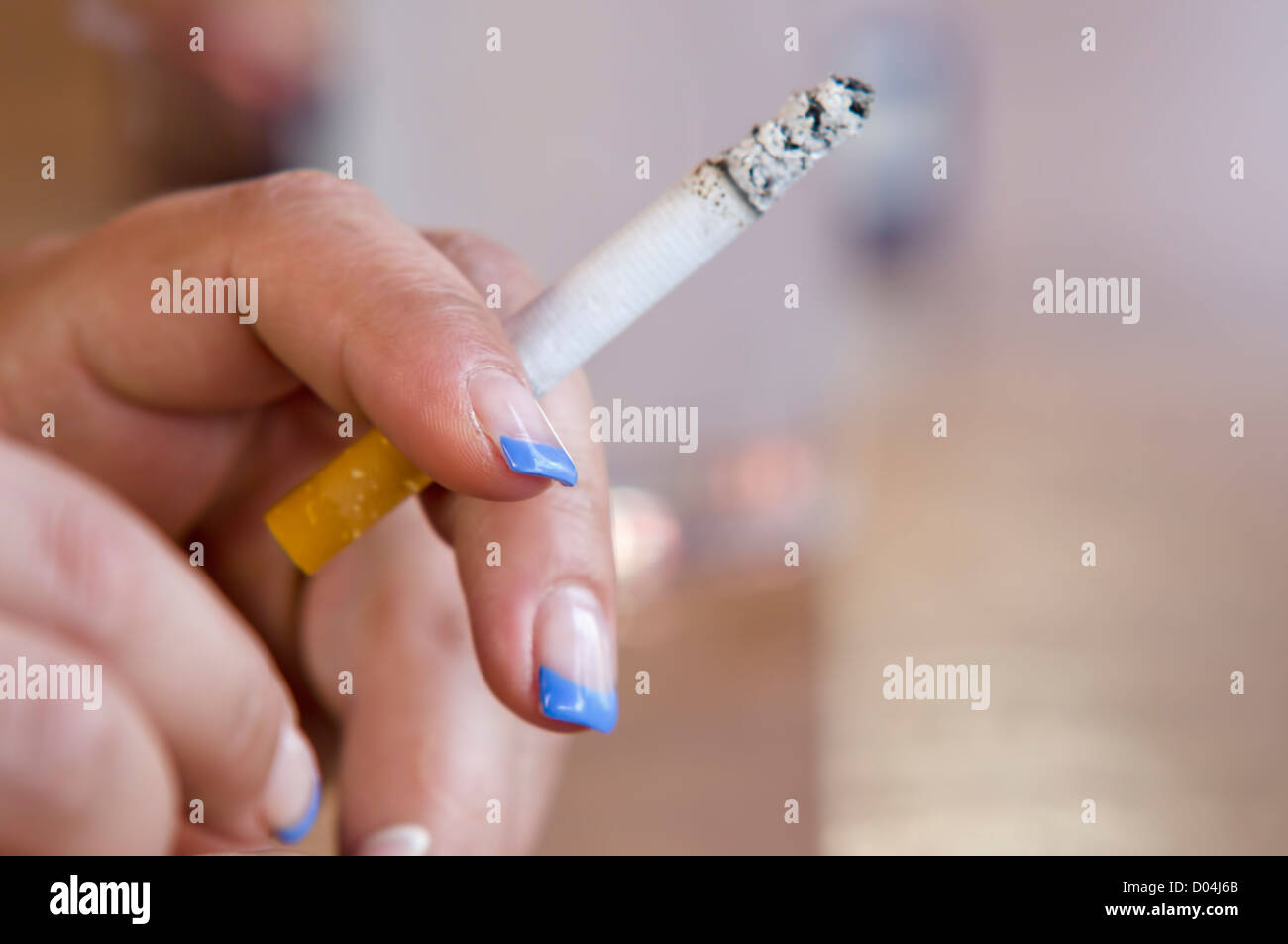 a cigarette in a woman's hand Stock Photo - Alamy