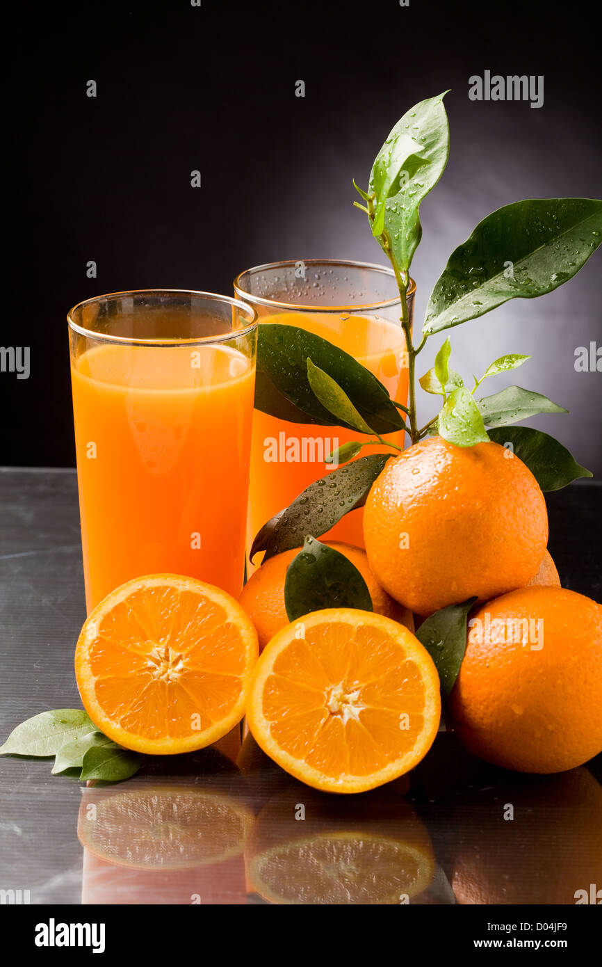 photo of fresh orange juice with water drops and green leaves Stock ...