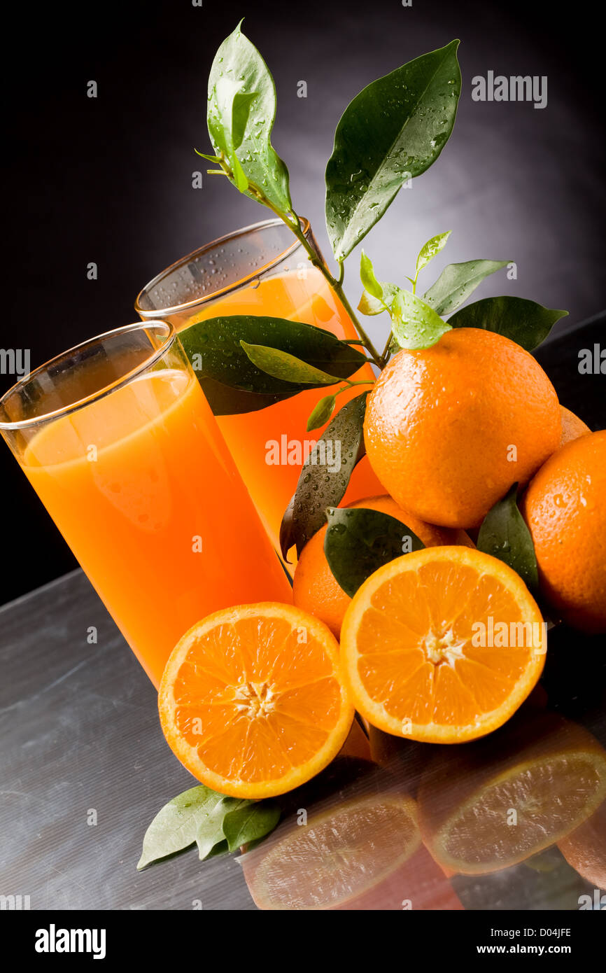 photo of fresh orange juice with water drops and green leaves Stock ...