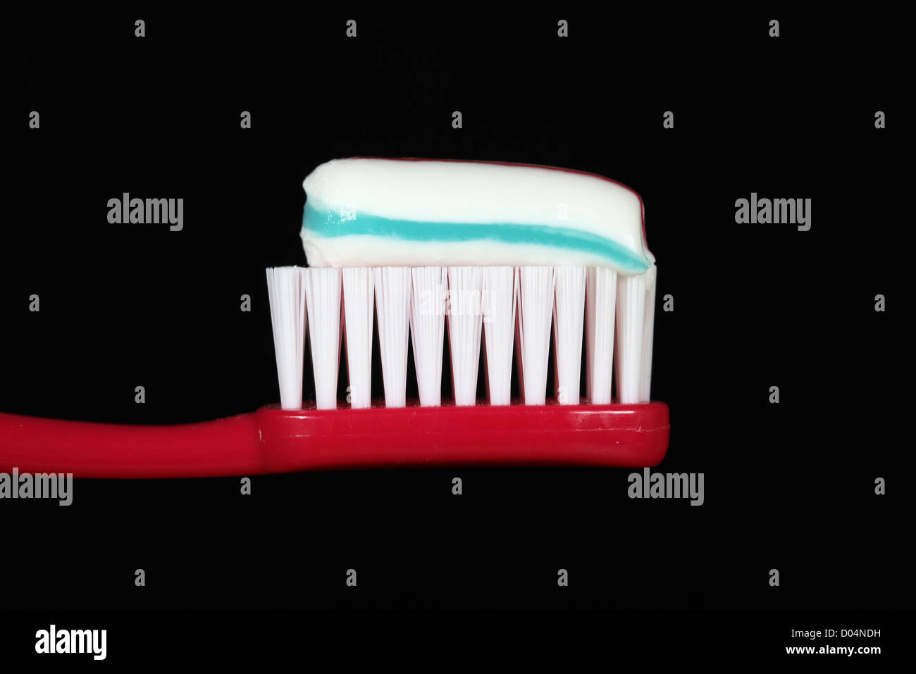 A red toothbrush on a black background, with a striped toothpaste Stock ...