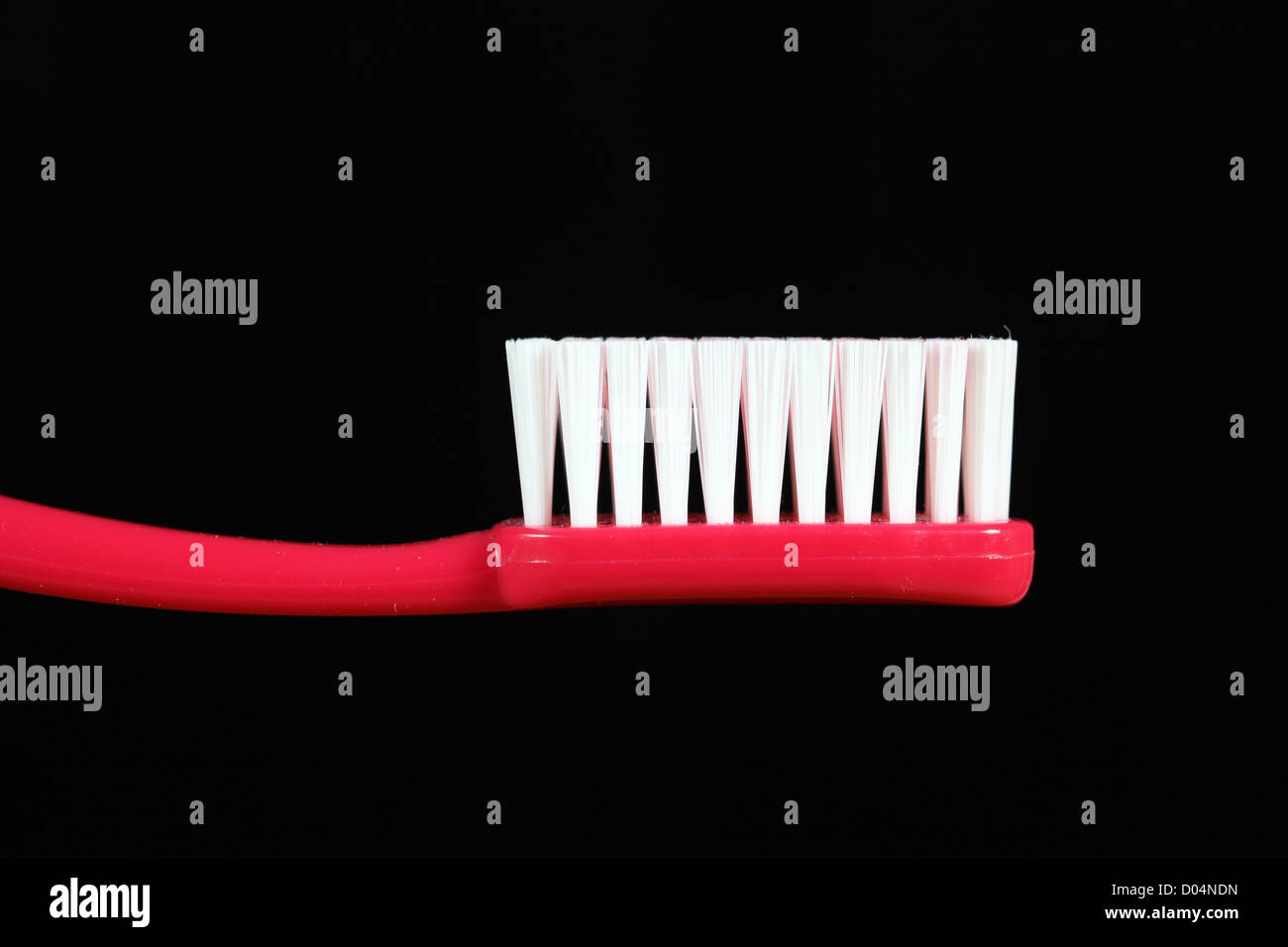 A red toothbrush on a black background Stock Photo - Alamy