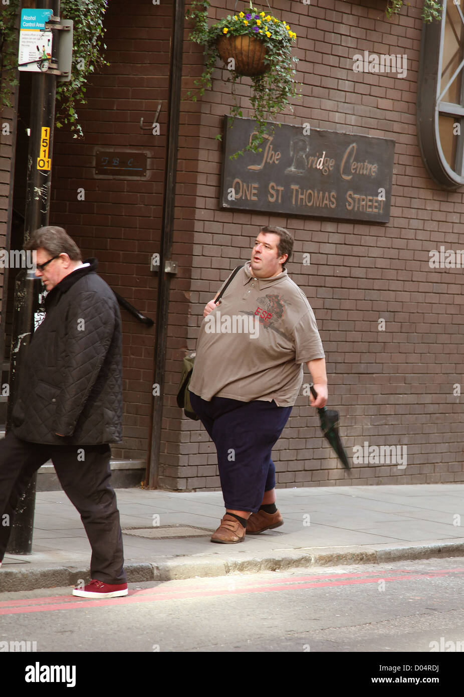 Very large overweight man walking through London, on St Thomas street ...