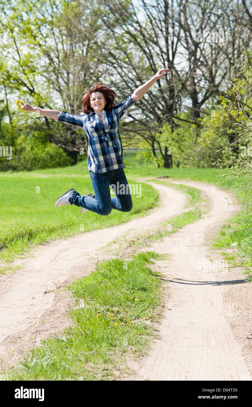 The happy woman has jumped up over road Stock Photo - Alamy