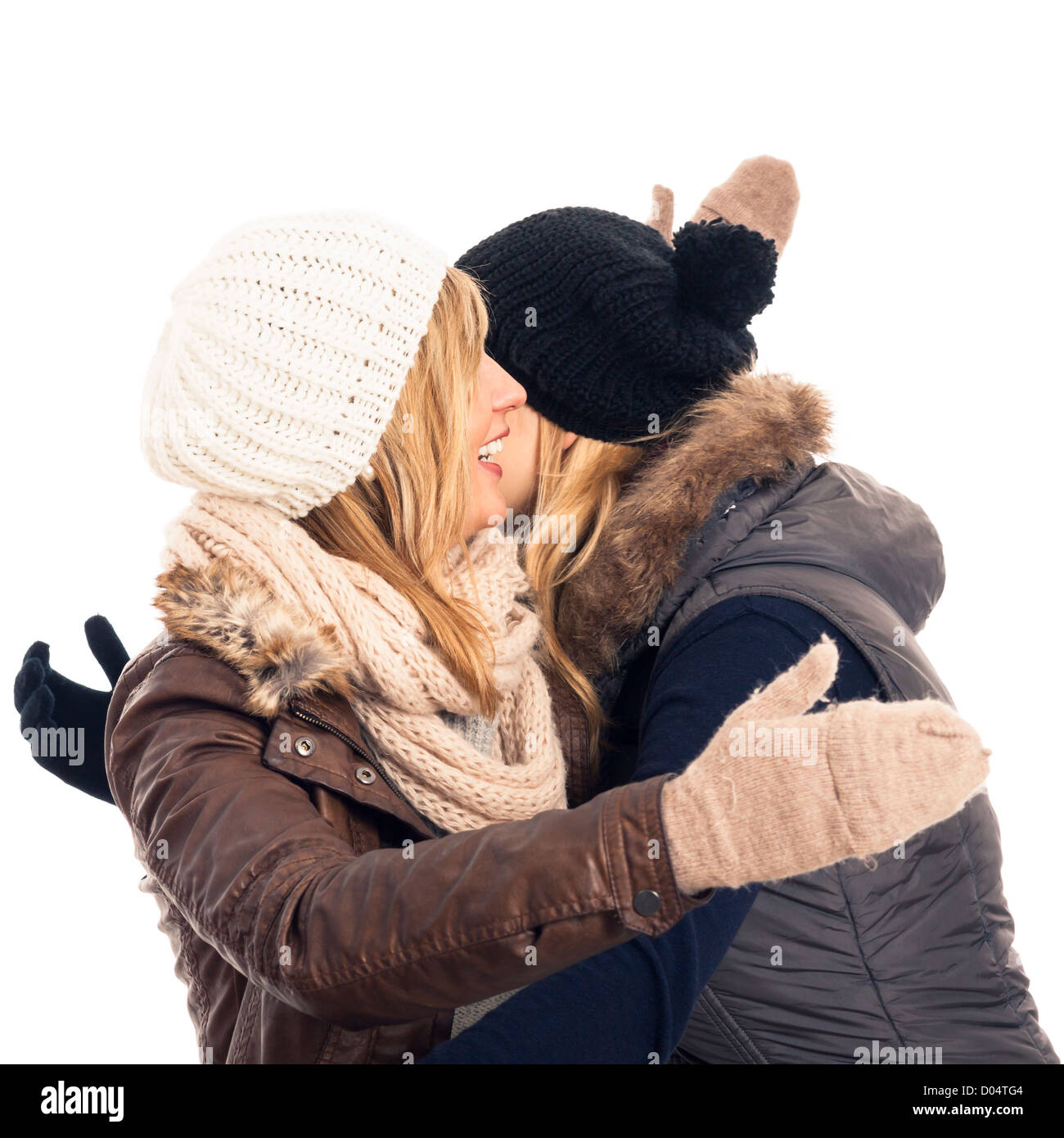 Two young happy friends in winter clothes greeting and hugging ...