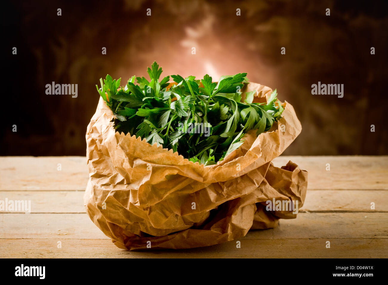 photo of fresh parsley inside a paper bag on wooden table Stock Photo ...