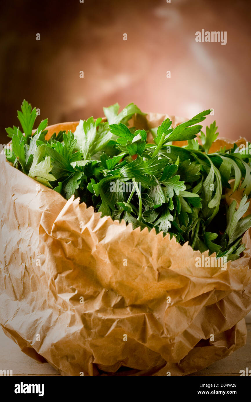 photo of fresh parsley inside a paper bag on wooden table Stock Photo ...