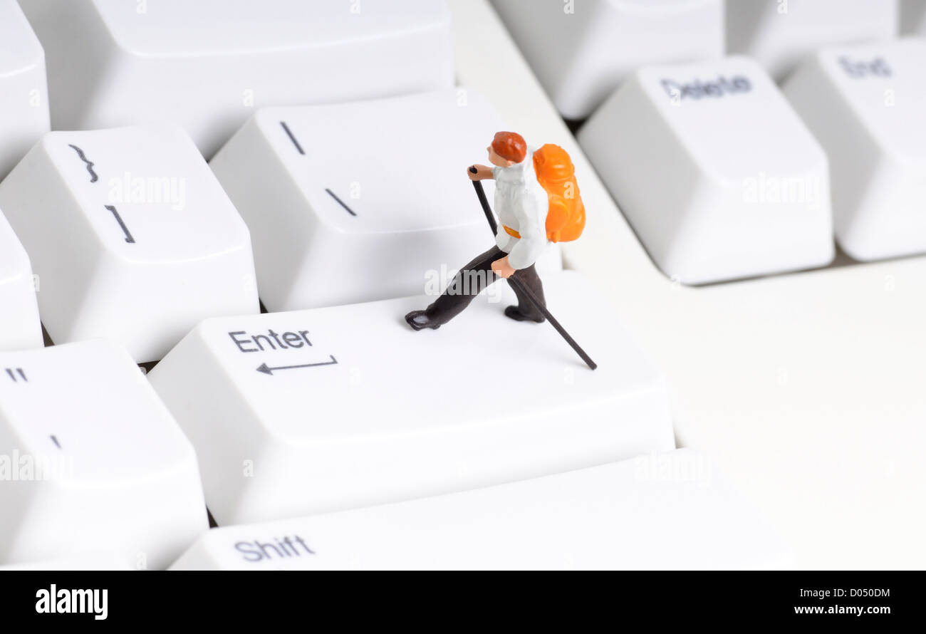 Tiny figure of hiker walking on enter key Stock Photo - Alamy