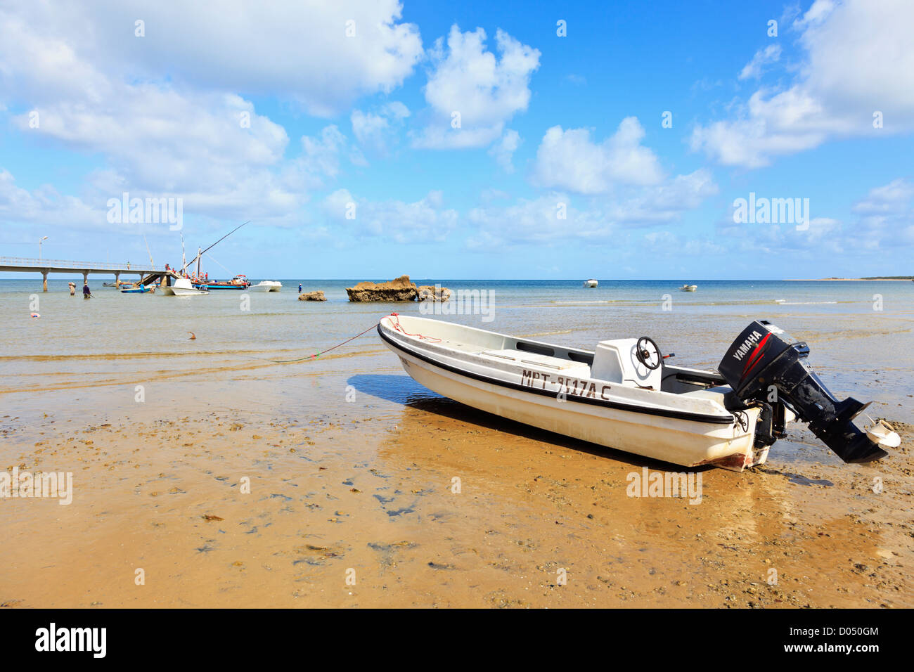 Dhows and a modern fishing boat lie stranded on the sand bank at low ...