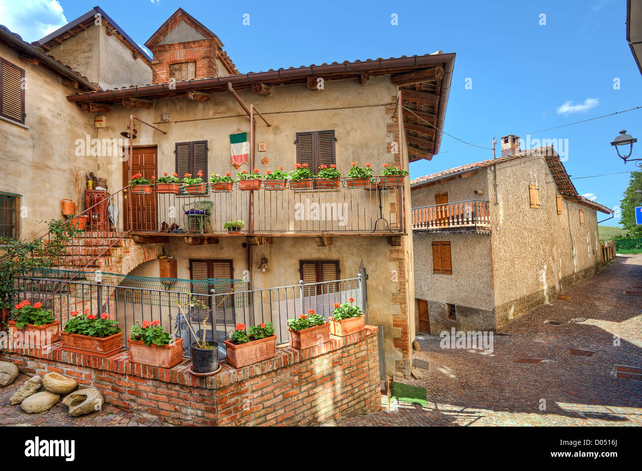 Traditional houses on narrow cobbled street of Barolo town in Piedmont ...