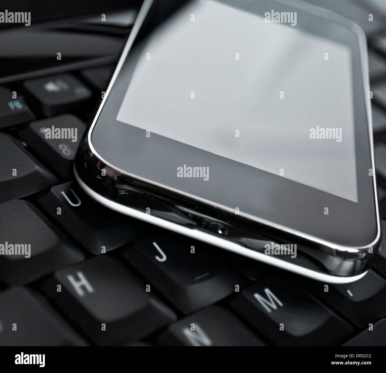 Cell phone on laptop keyboard - Business concept Stock Photo - Alamy