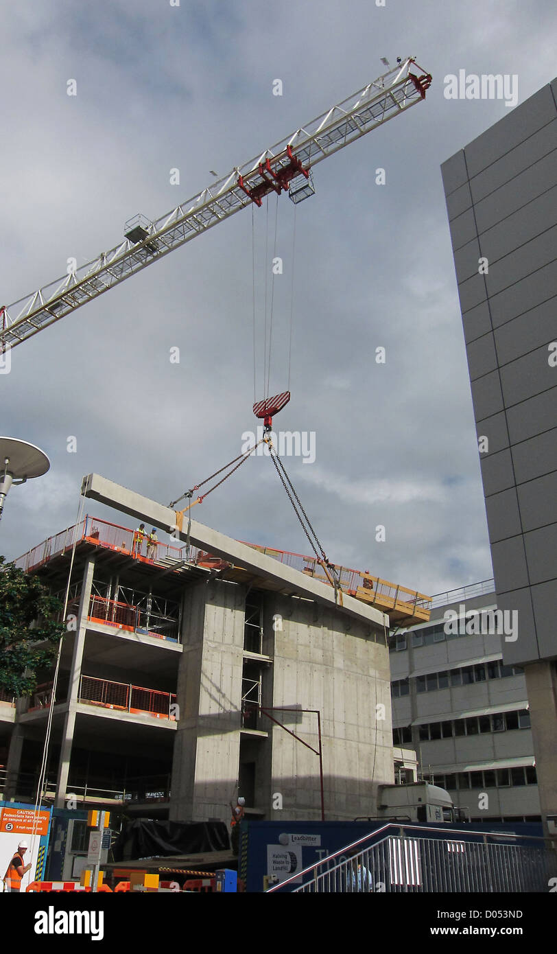 July 2011 - Construction workers unloading a concrete beam from a truck ...
