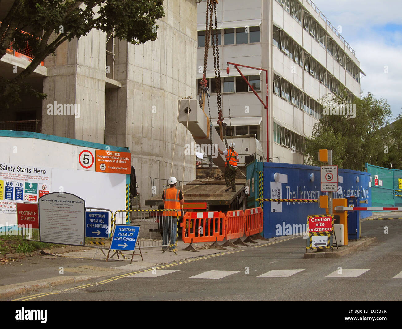 July 2011 - Construction workers unloading a concrete beam from a truck ...
