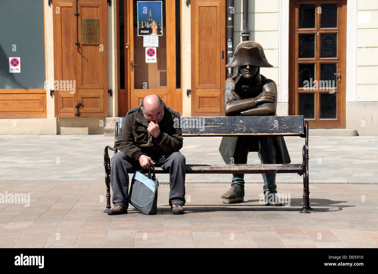 A man sitting on a bench with a Napoleonic French soldier street art ...