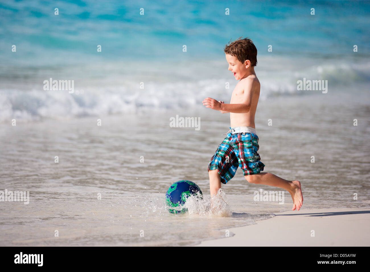 Boy playing with ball on beach Stock Photo - Alamy