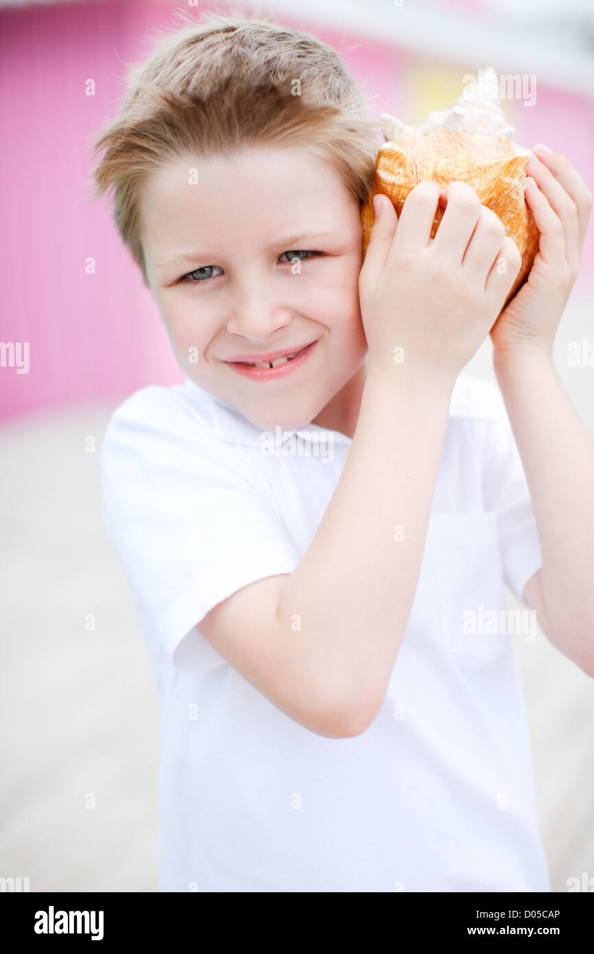 Cute boy with seashell Stock Photo - Alamy