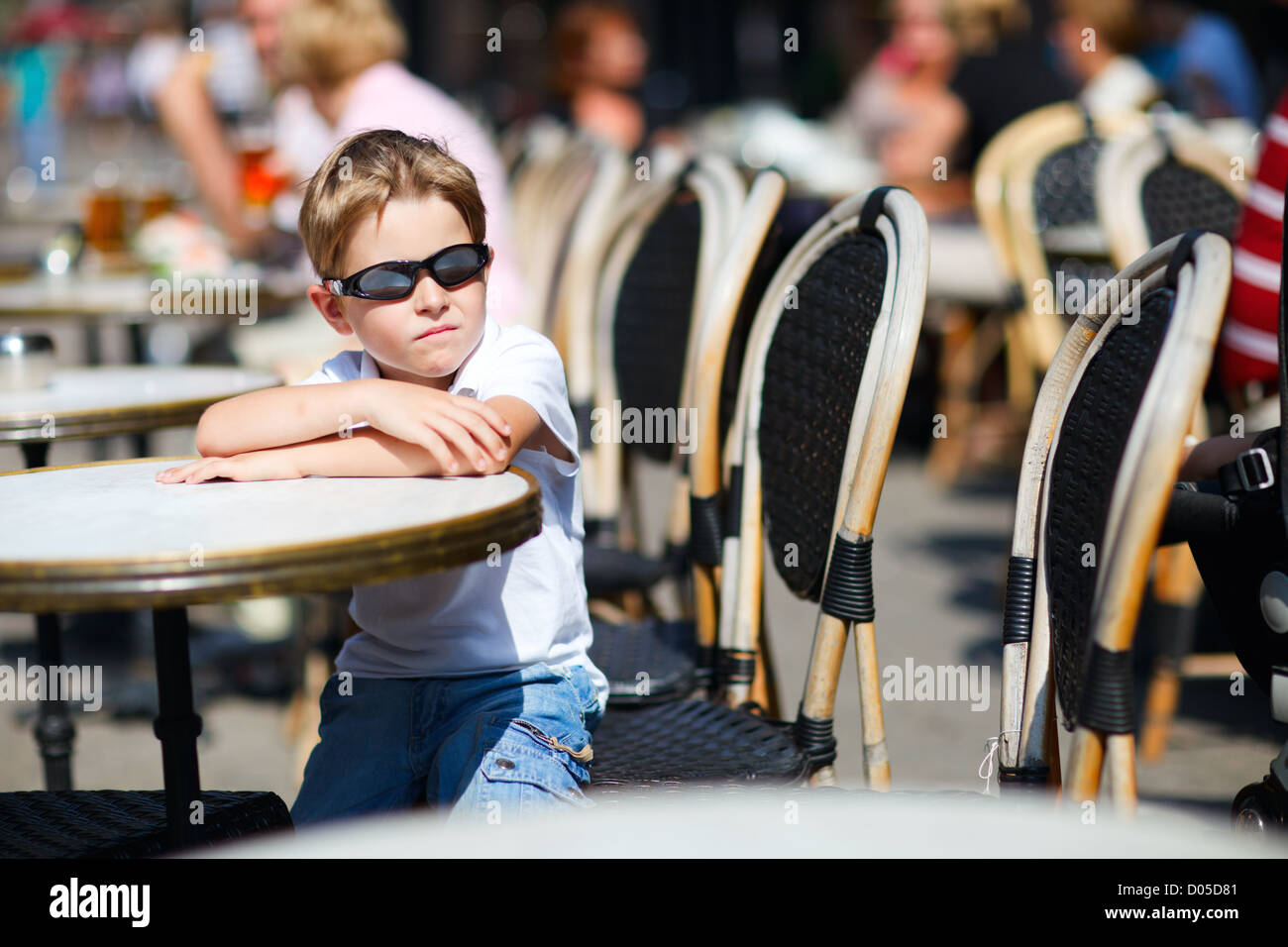 Cute boy sitting in outdoor cafe Stock Photo - Alamy