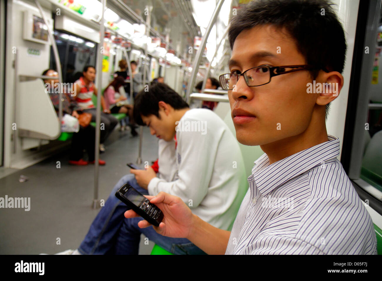 Group of people using phones subway hi-res stock photography and images ...