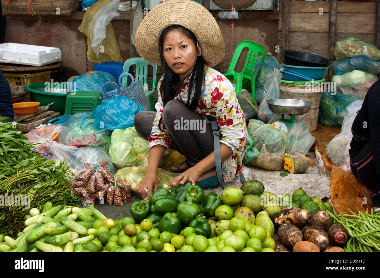 Young Khmer woman with a hat selling fruits and vegetables on a local ...