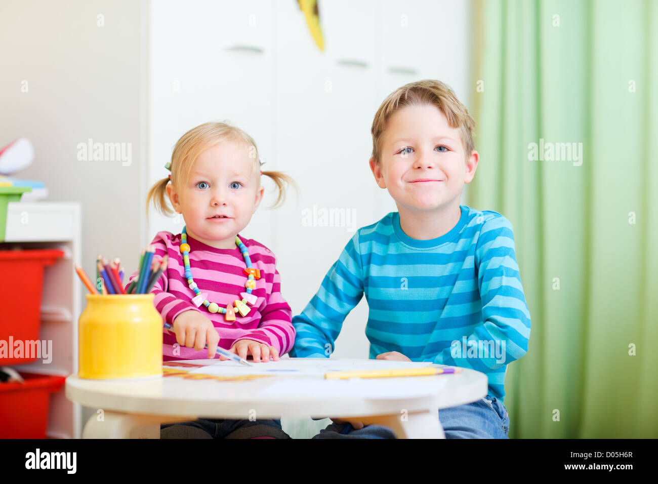 Two kids drawing with coloring pencils Stock Photo - Alamy
