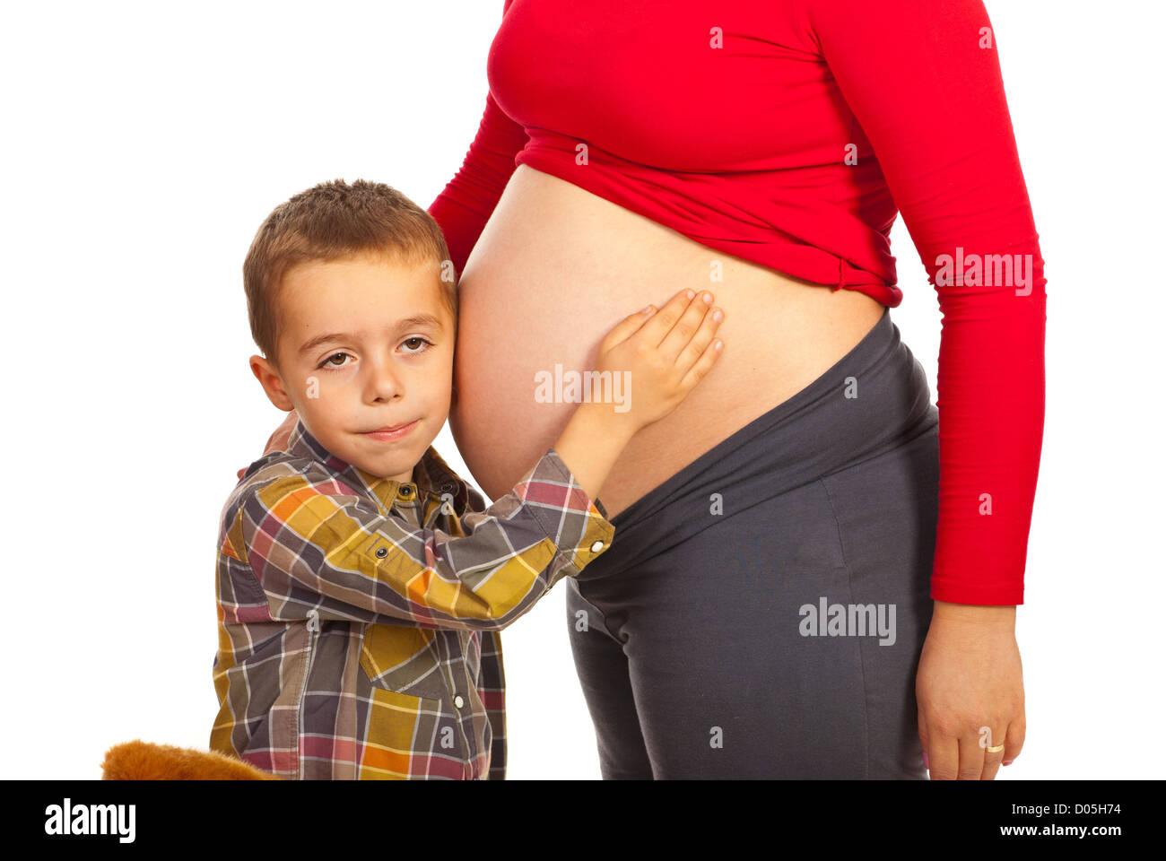 Boy listening his mother pregnant belly isolated on white background ...