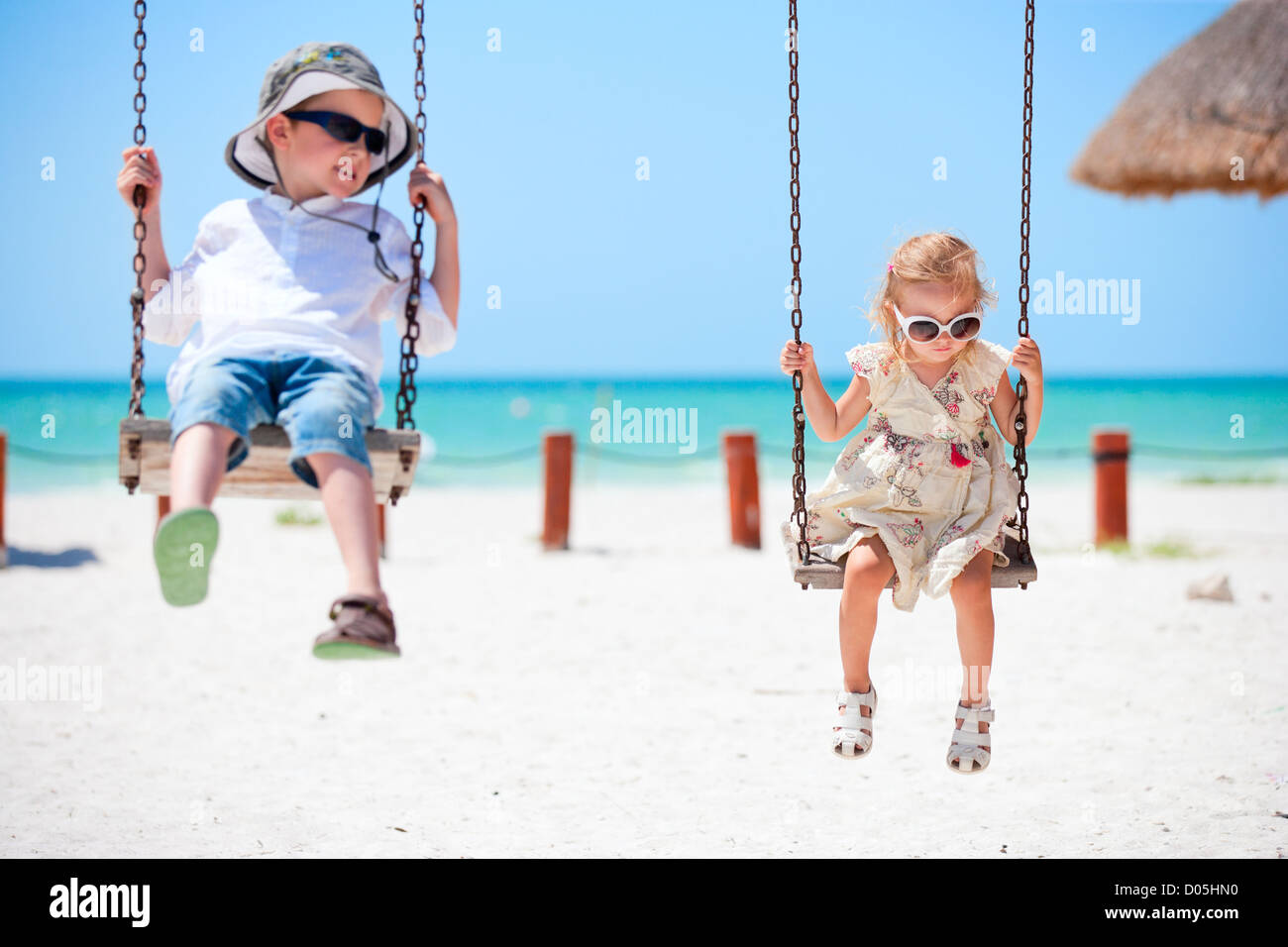 Little kids swinging Stock Photo - Alamy