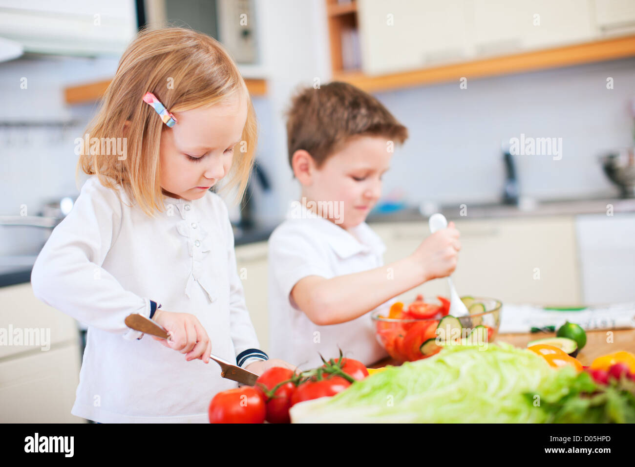 Two little kids making salad Stock Photo - Alamy