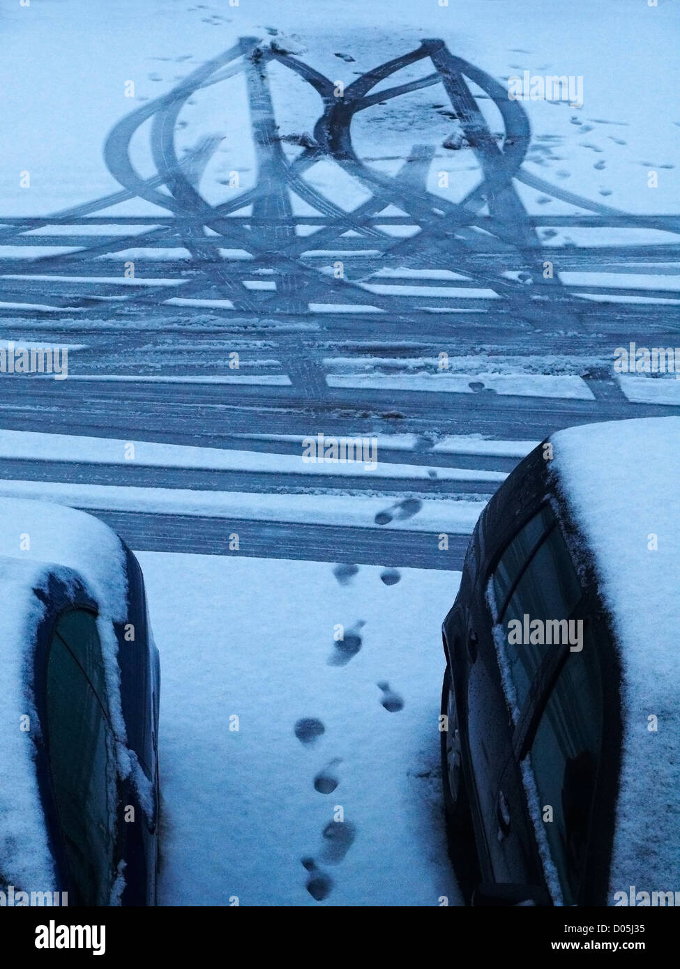 Foot prints with tyre tracks of reversing car in snow Stock Photo - Alamy