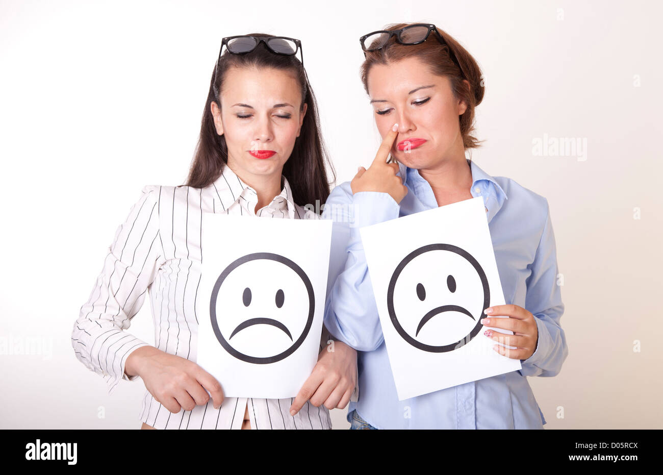 Portrait of a two young beautiful women holding sad smiley faces Stock ...