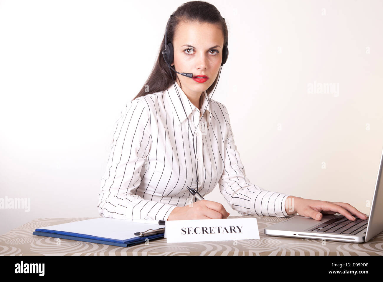 Portrait of a young beautiful secretary with headphones working Stock ... Portrait of a young beautiful secretary with headphones working Stock ...